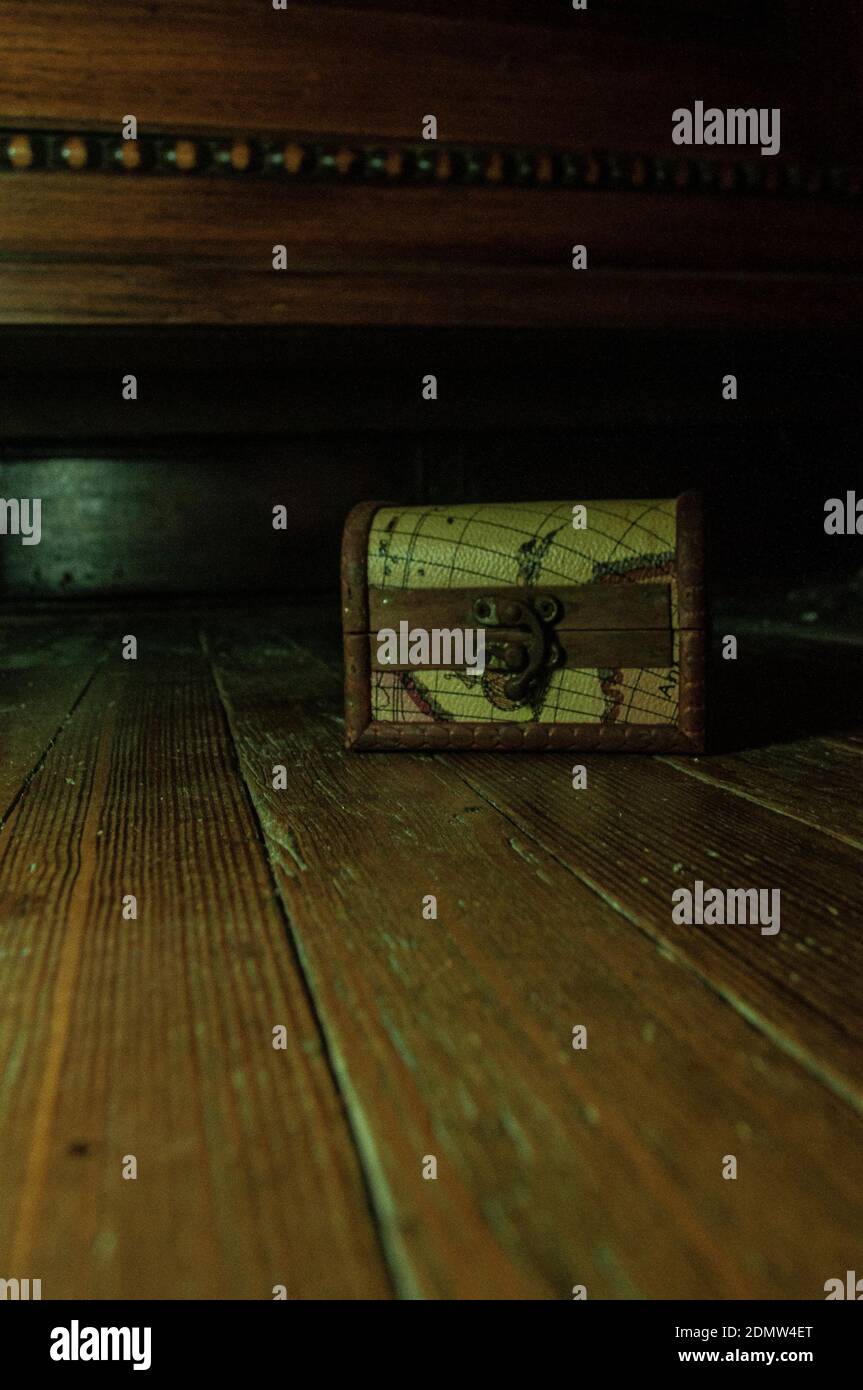 A vertical shot of an old wooden chest with a vintage map pattern on ...