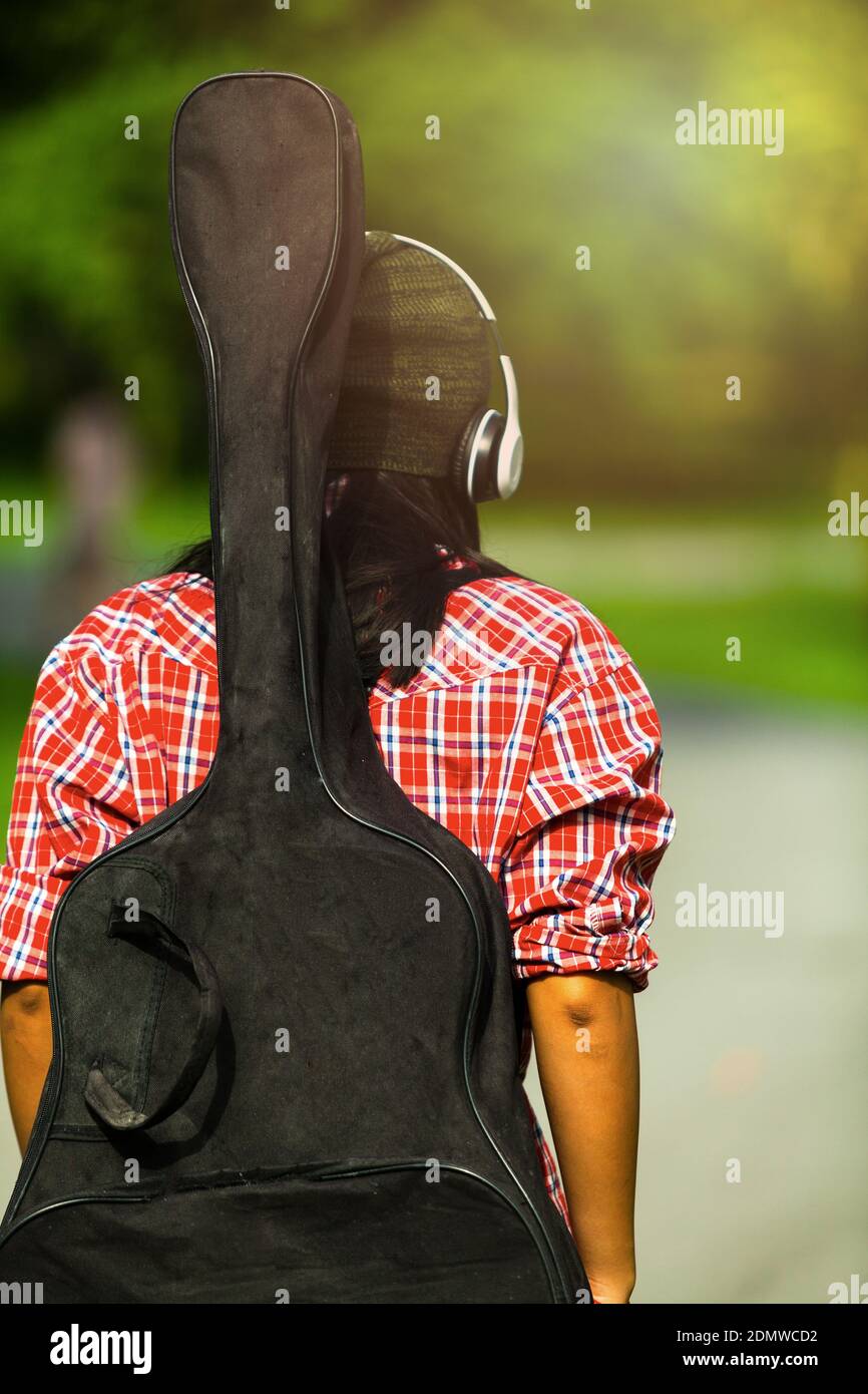 Woman carrying guitar case hi-res stock photography and images - Alamy