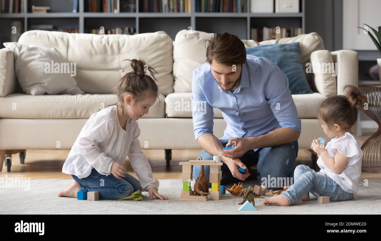 Wide view of caring dad play at home with daughters Stock Photo - Alamy
