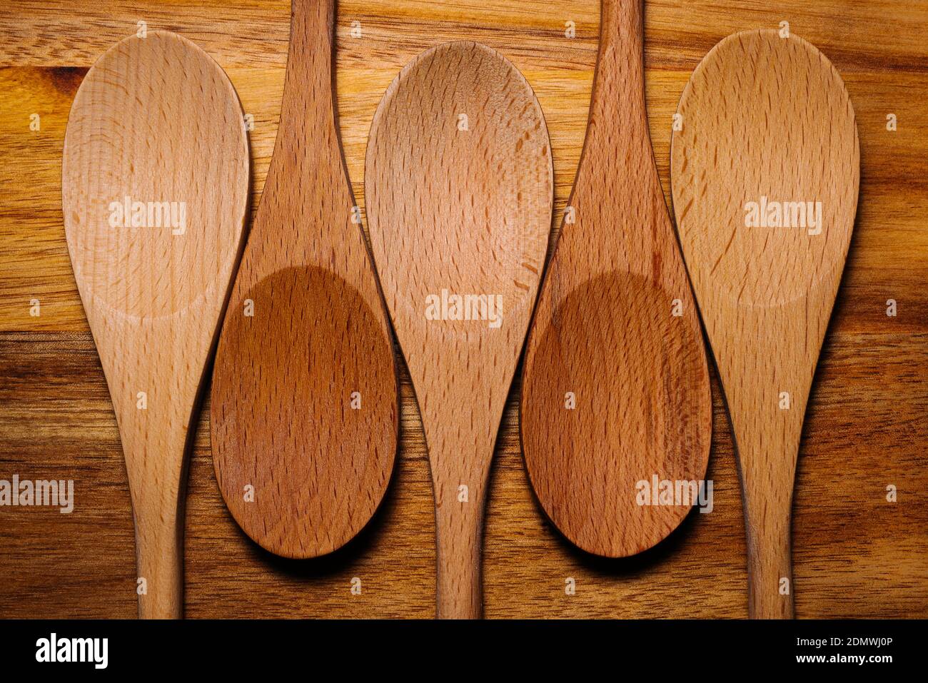 Five wood spoons on textured wood background in repeating pattern Stock ...