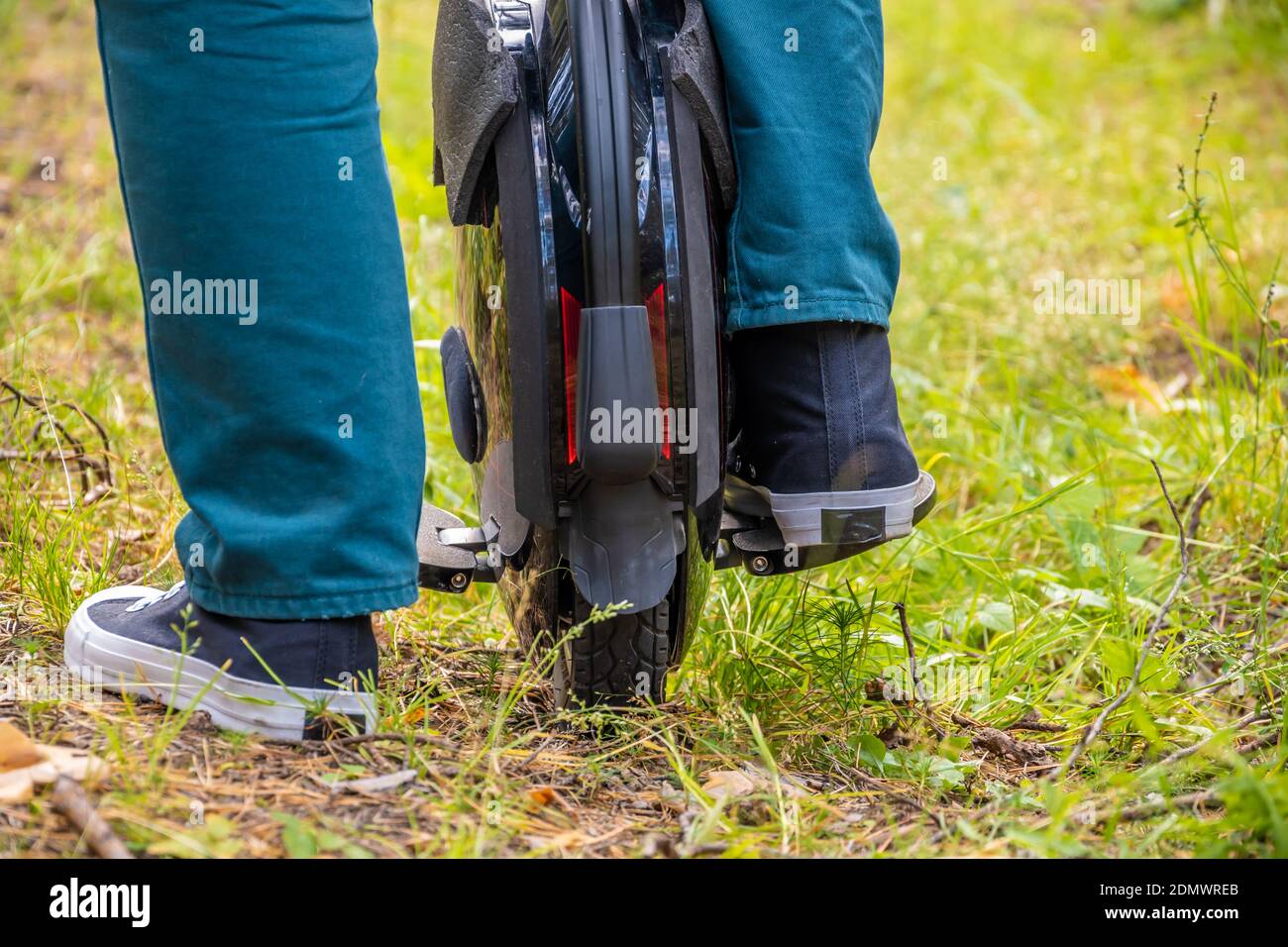 Rear view of men's legs on an electric unicycle in the forest Stock ...