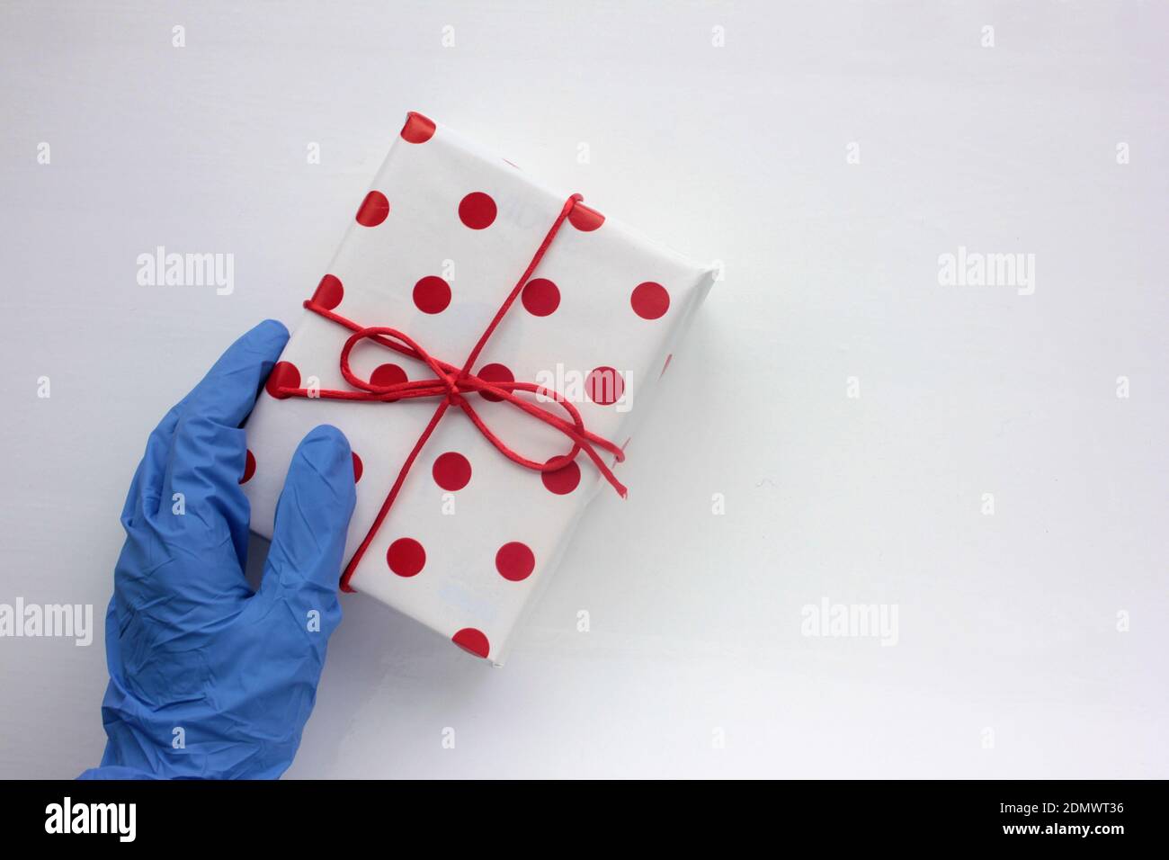 Hand in medical glove with a present. Overhead view of wrapped gift box ...