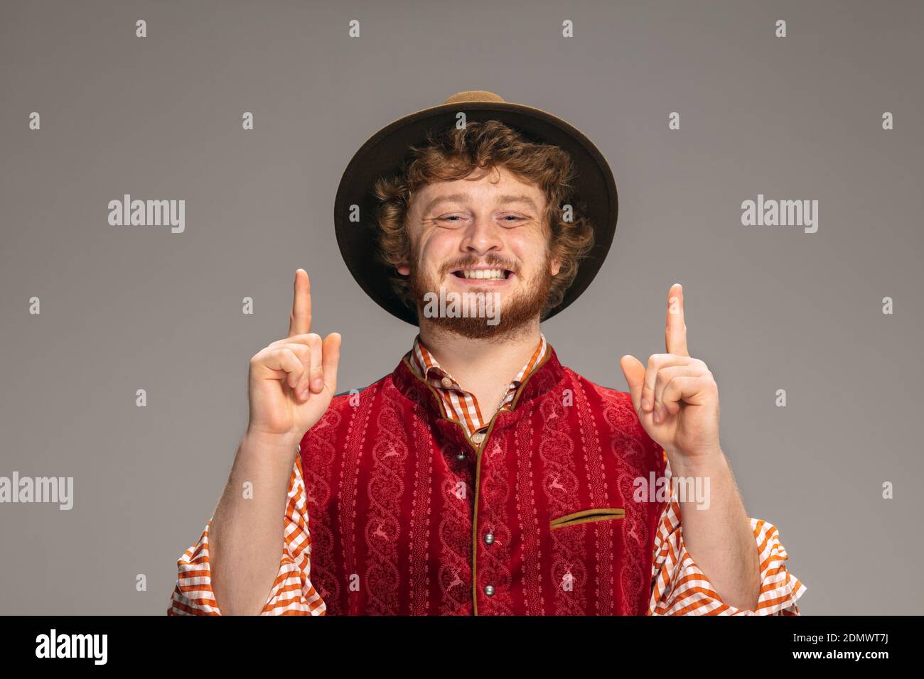 Pointing. Happy smiling man dressed in traditional Austrian or Bavarian ...