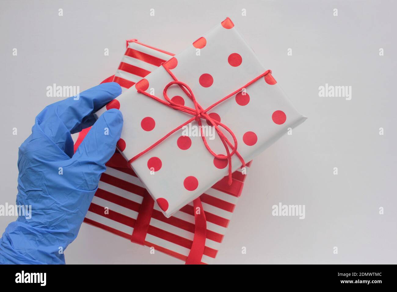 Hand in medical glove with a present. Overhead view of wrapped gift box ...
