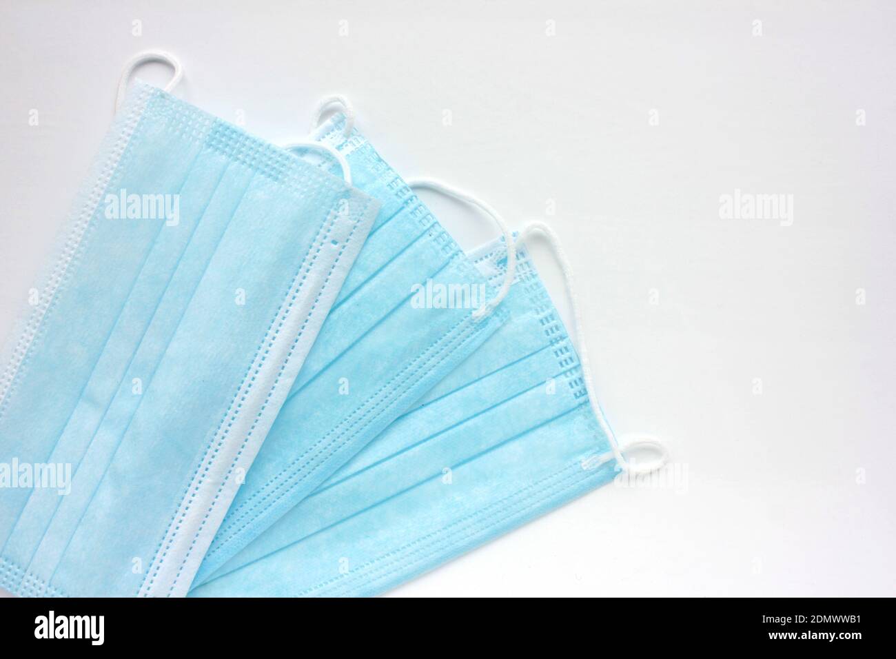 Pandemic face mask on white background. Overhead view of pile of blue ...