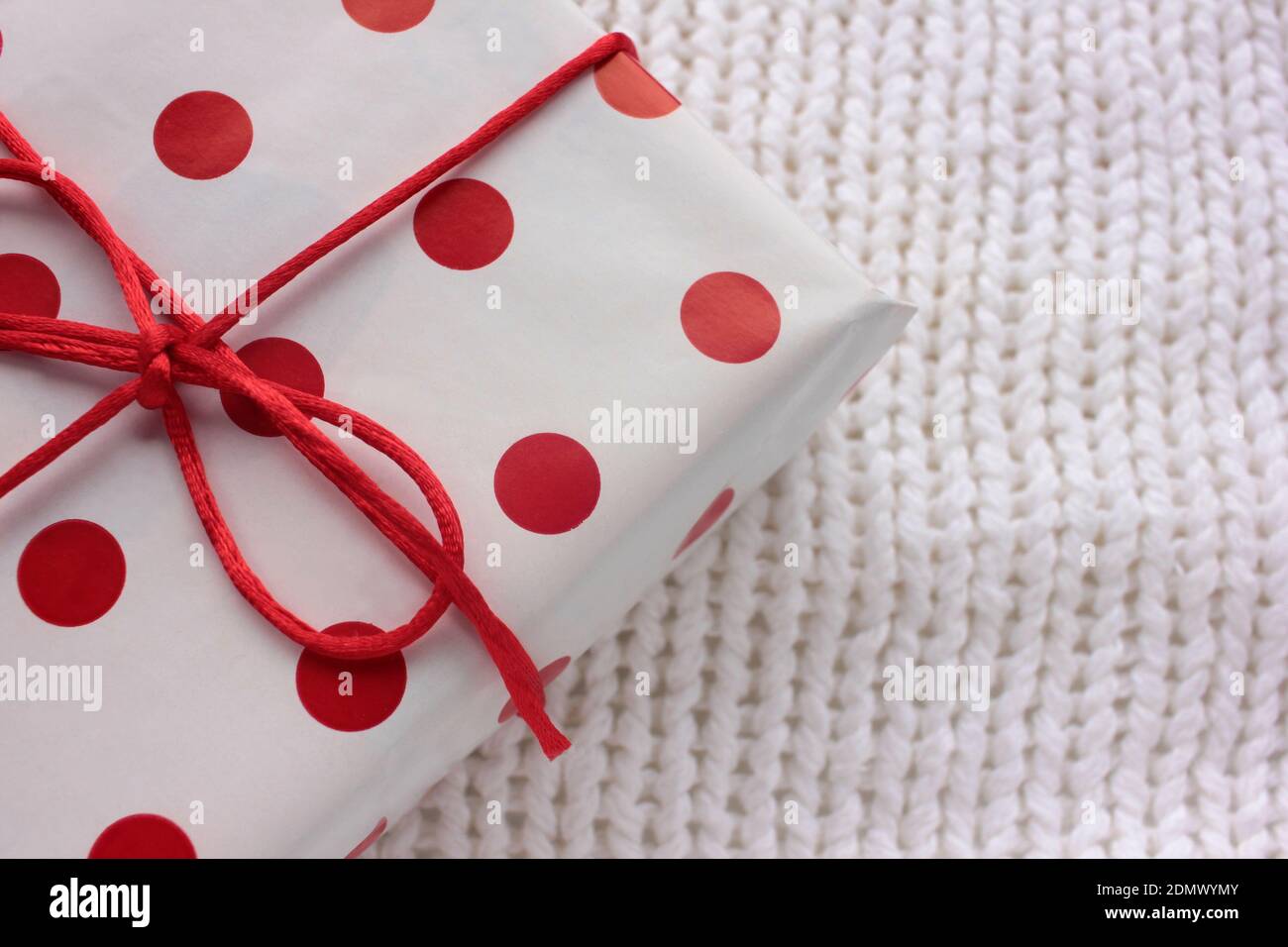 Gift box wrapped in red and white wrapping paper and tied with ribbon ...
