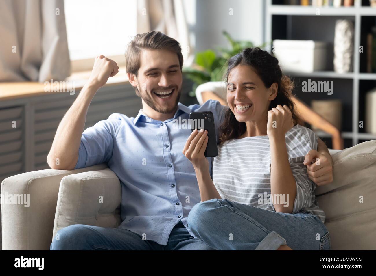 Overjoyed couple celebrate good message on cellphone Stock Photo - Alamy
