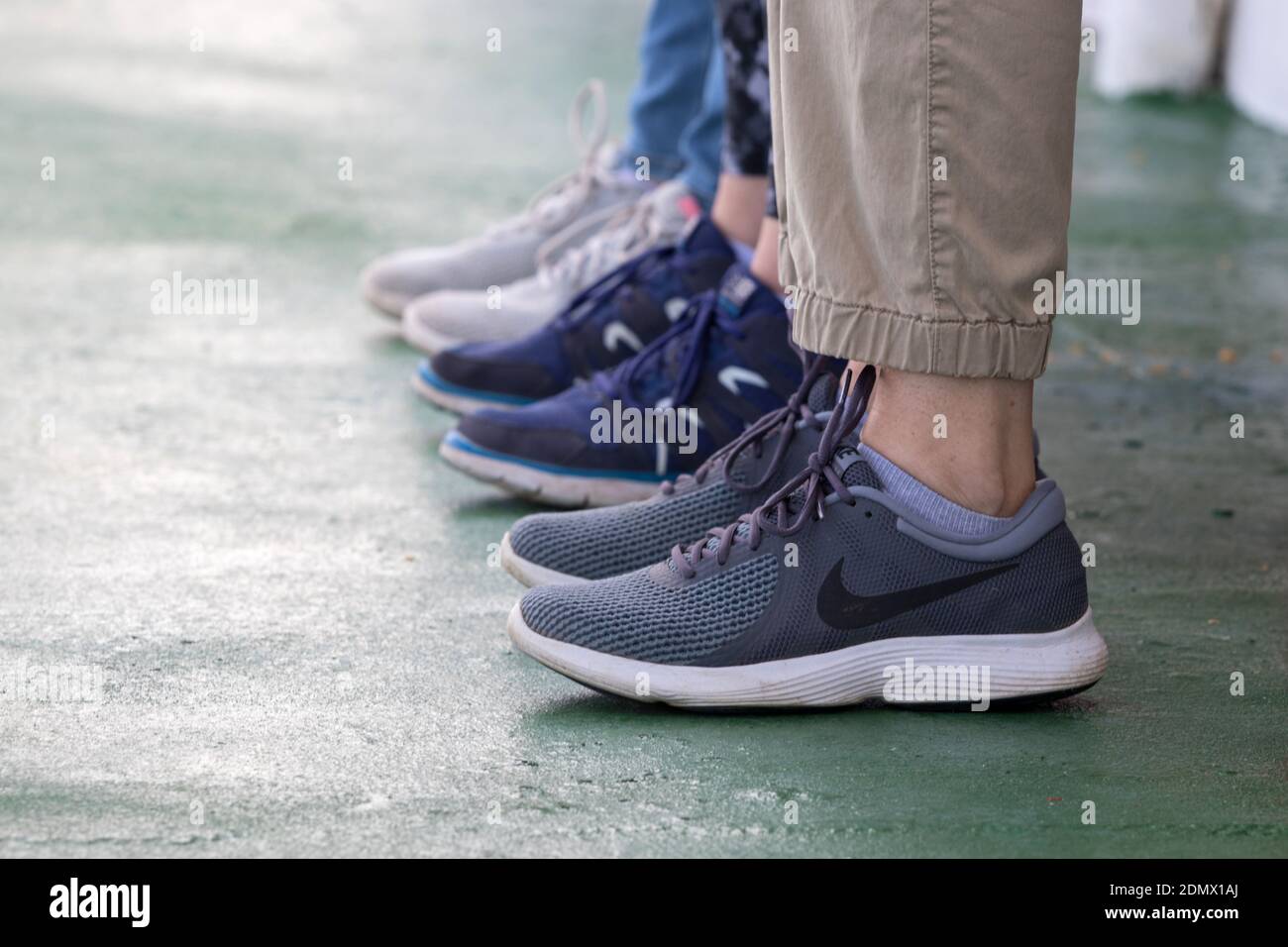 Three pairs of trainers in a row Stock Photo - Alamy