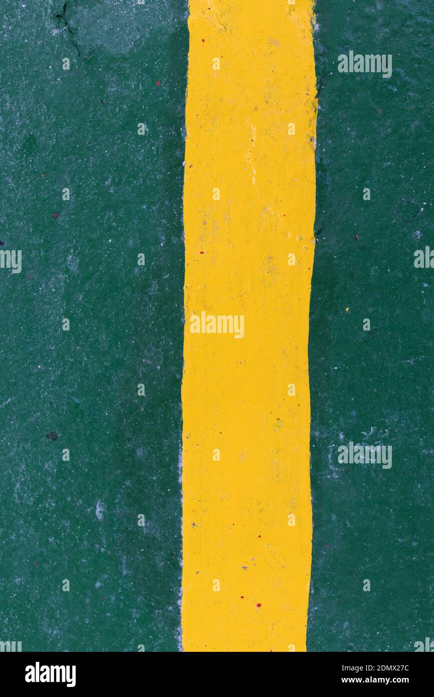 Abstract yellow painted line on a green background Stock Photo - Alamy