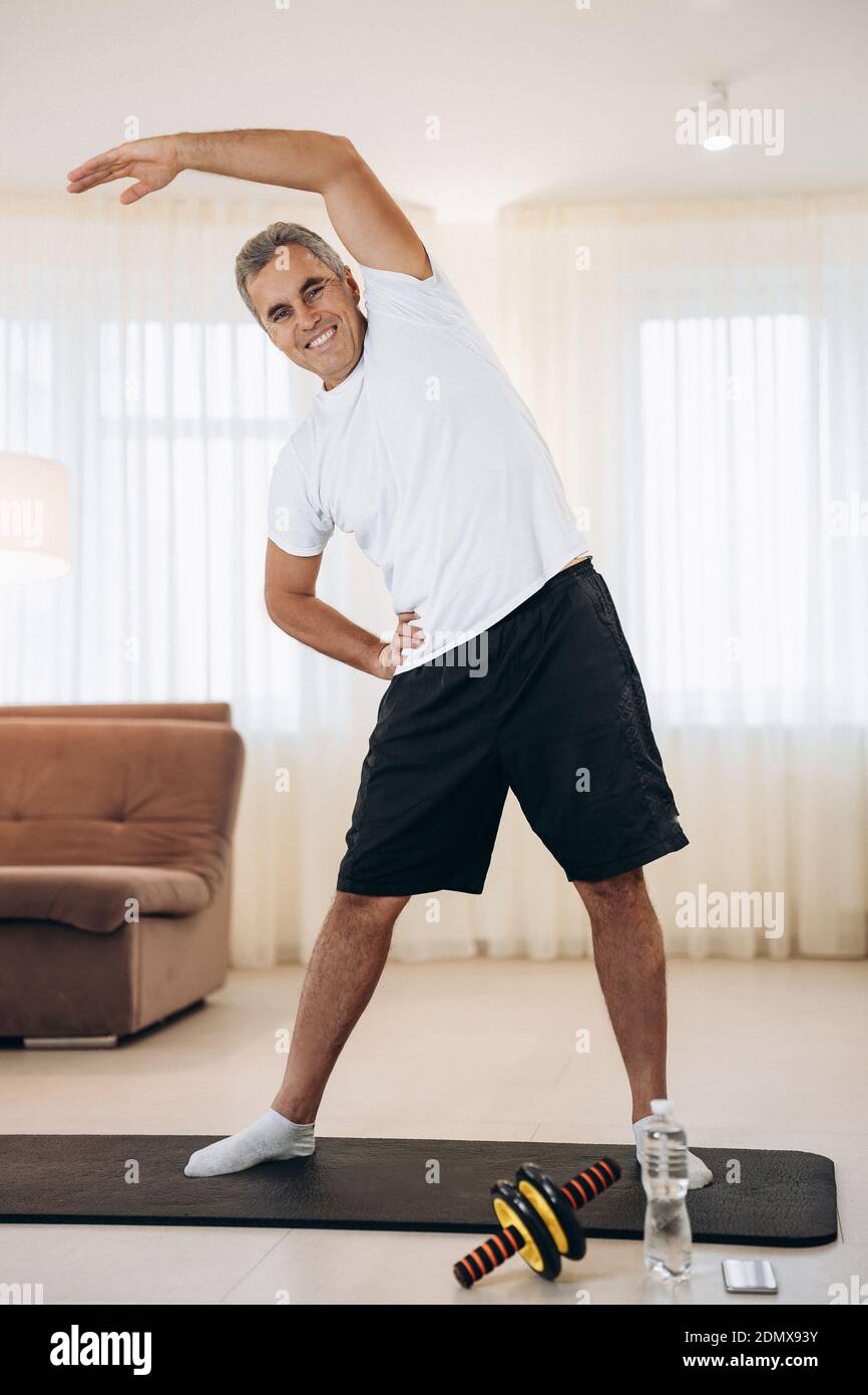 Warm up first Cheerful senior man stretching his arms, smiling and ...