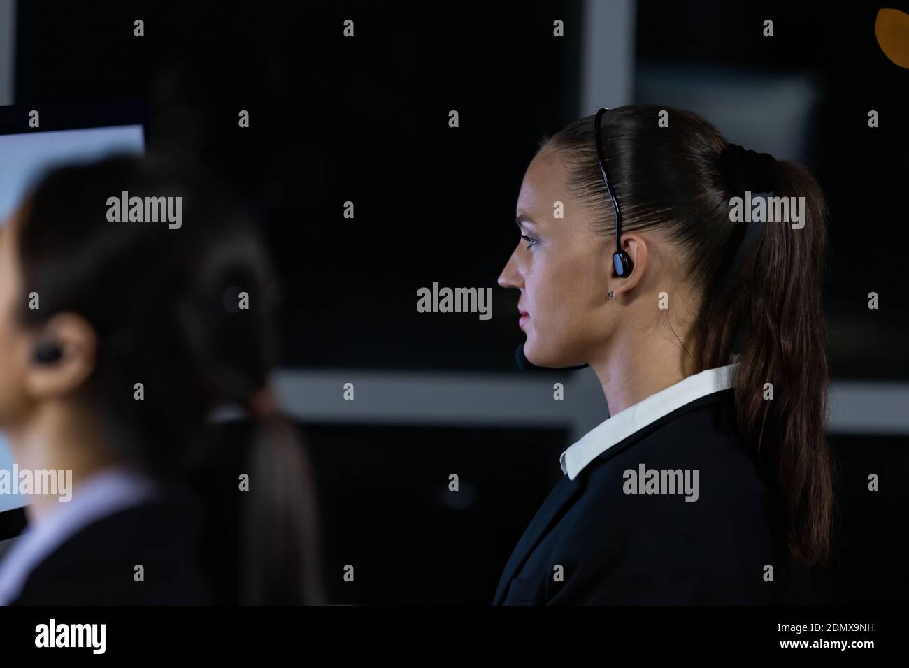 Caucasian young woman wearing headphone headset working overtime late ...