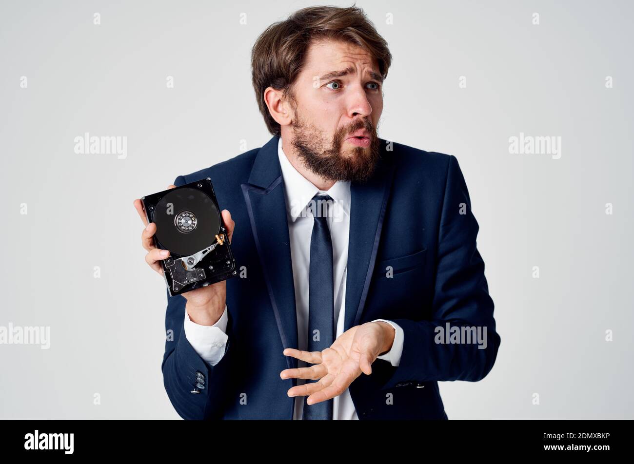 man with a hard drive in his hands emotions light background business ...