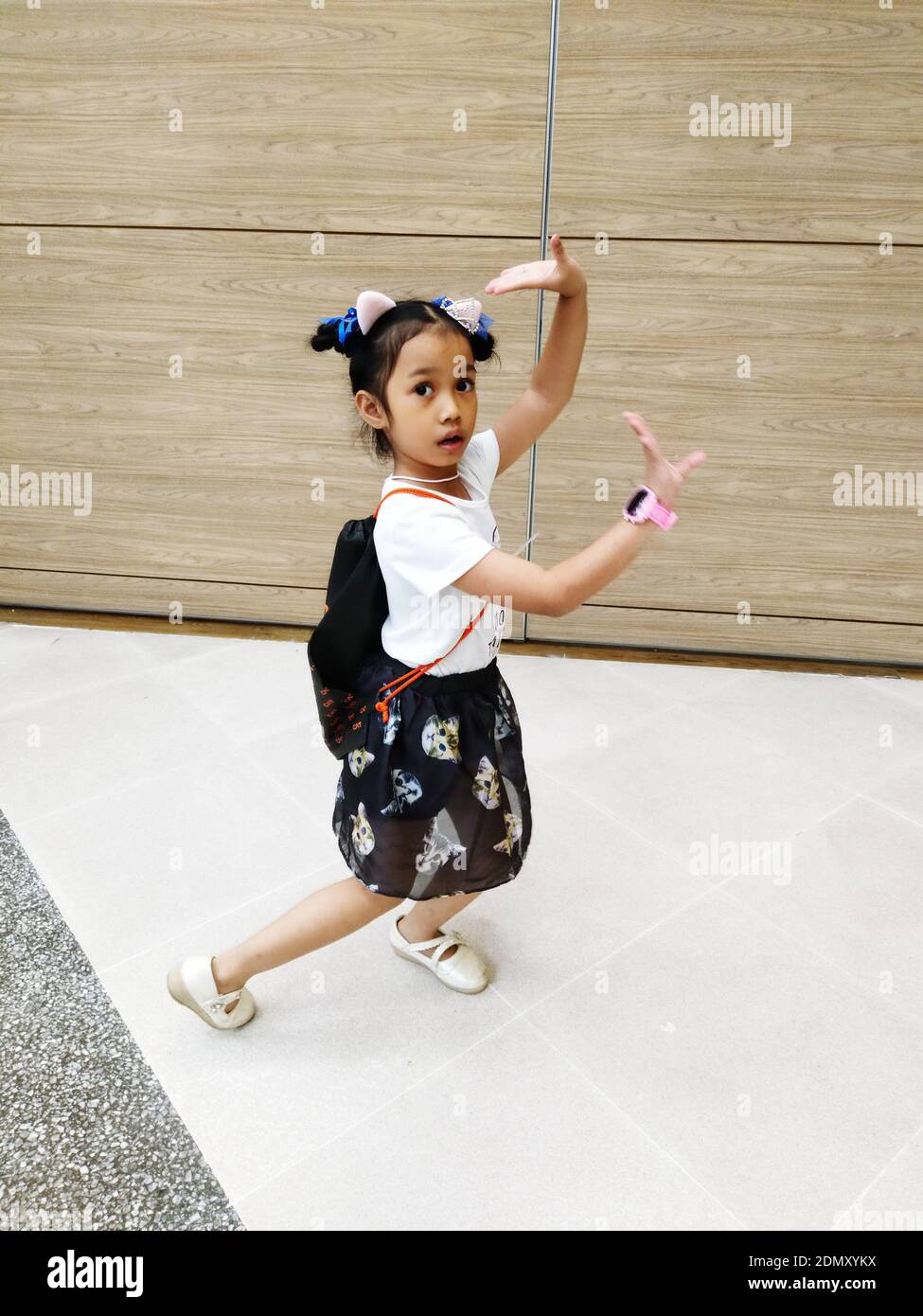 Portrait Of Cute Girl With Backpack Dancing Against Wall Stock Photo ...