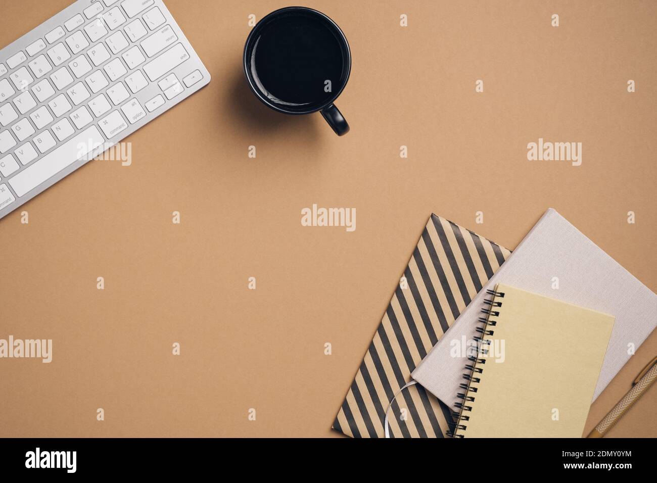 Modern office desk with keyboard, cup of coffee, paper notebooks and ...
