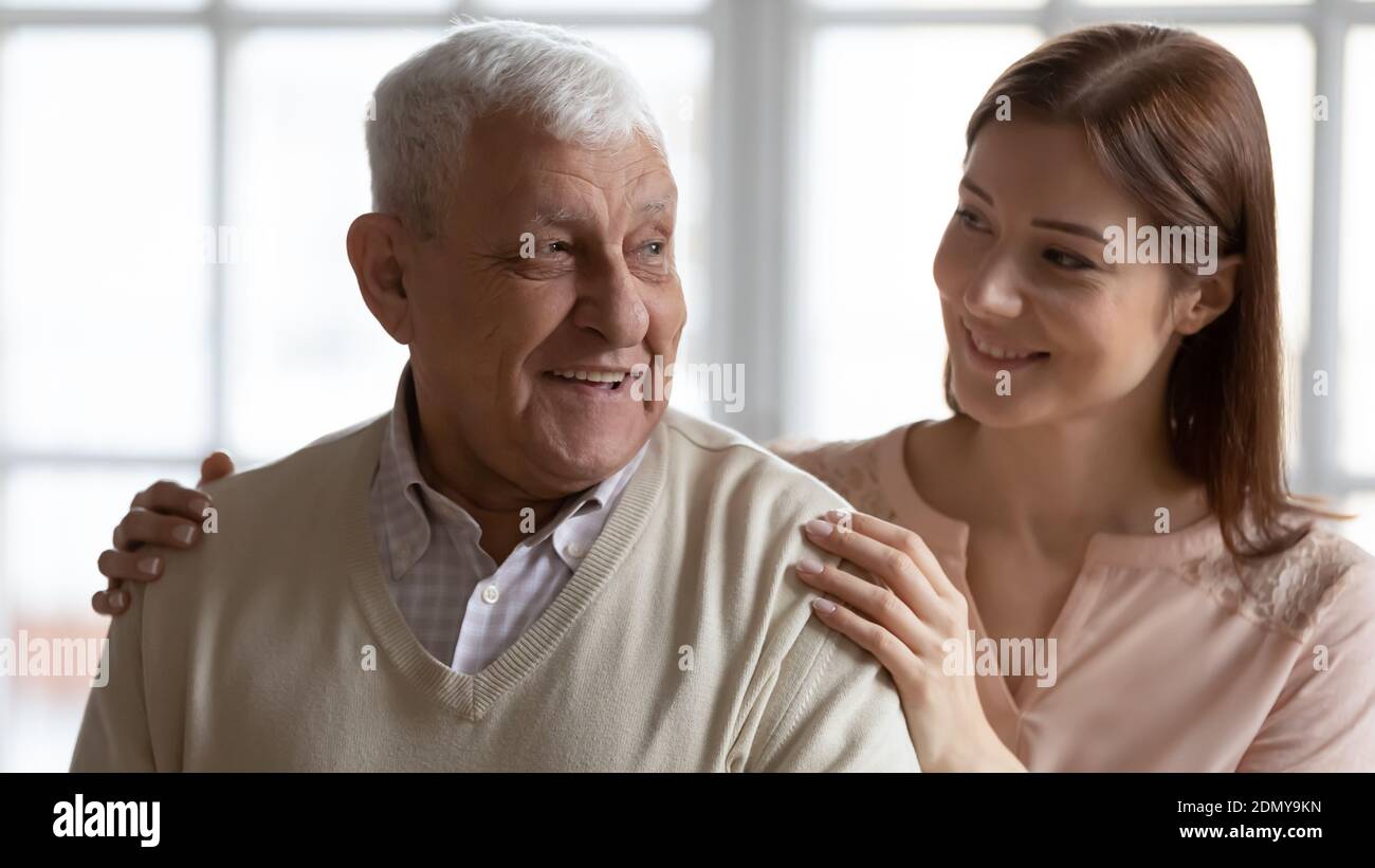 Young lady caregiver asking elderly man patient about his needs Stock ...