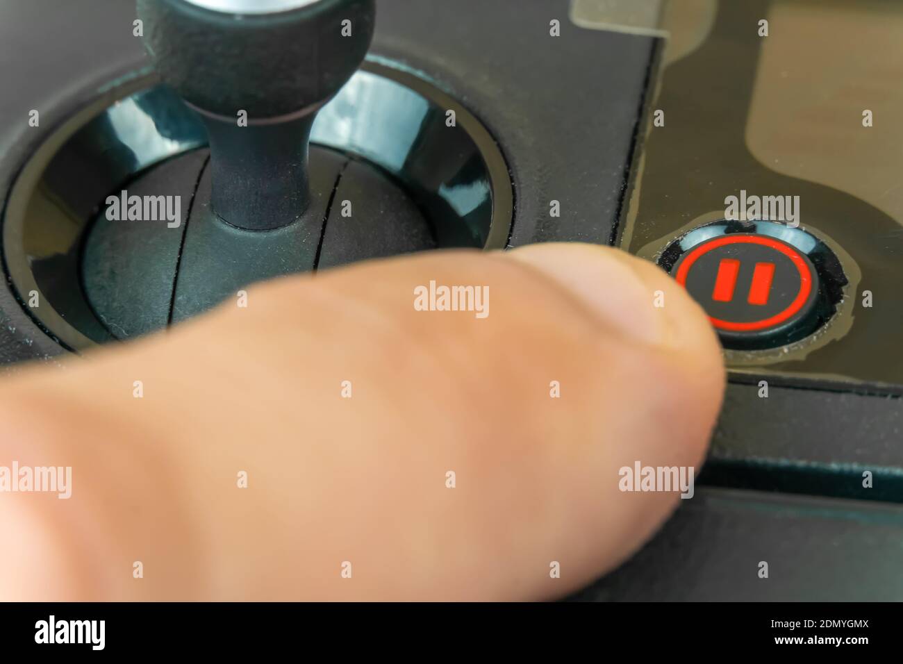 Man's hand presses the Pause button on the remote control of the drone ...