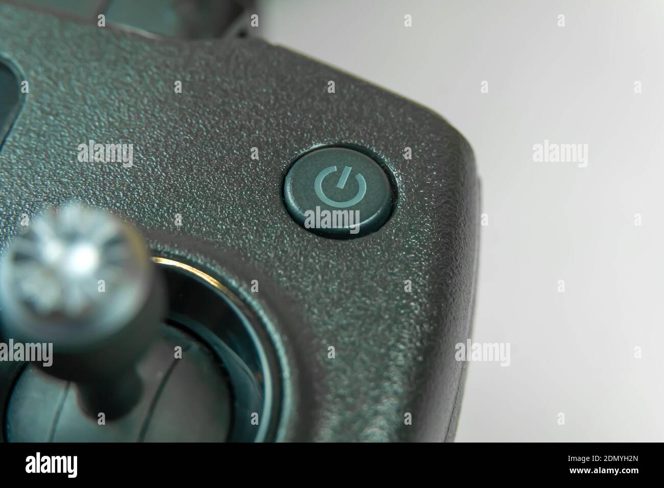 A man's hand presses the home button on the remote control of the drone ...