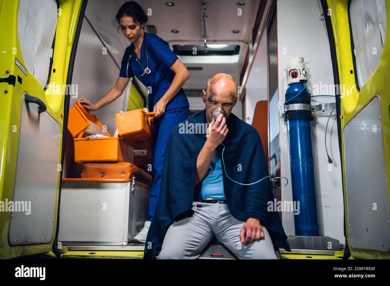 Man Sitting With An Oxygen Mask In An Ambulance Car A Nurse Looking
