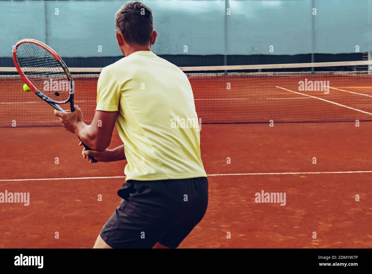 Tennis player standing with racket on tennis court Stock Photo - Alamy