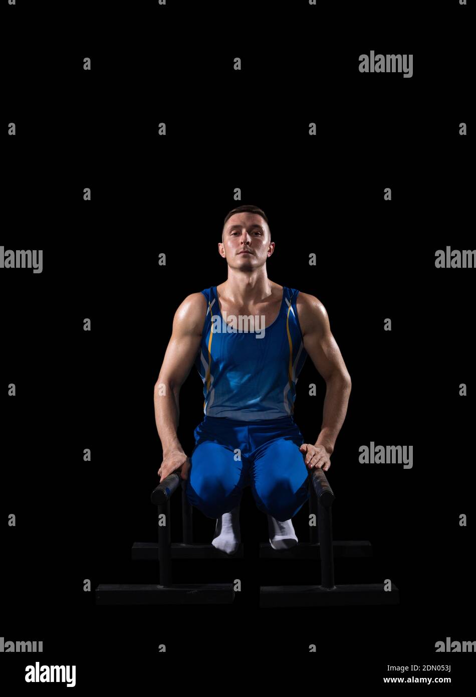 Energy. Muscular male gymnast training in gym, flexible and active ...