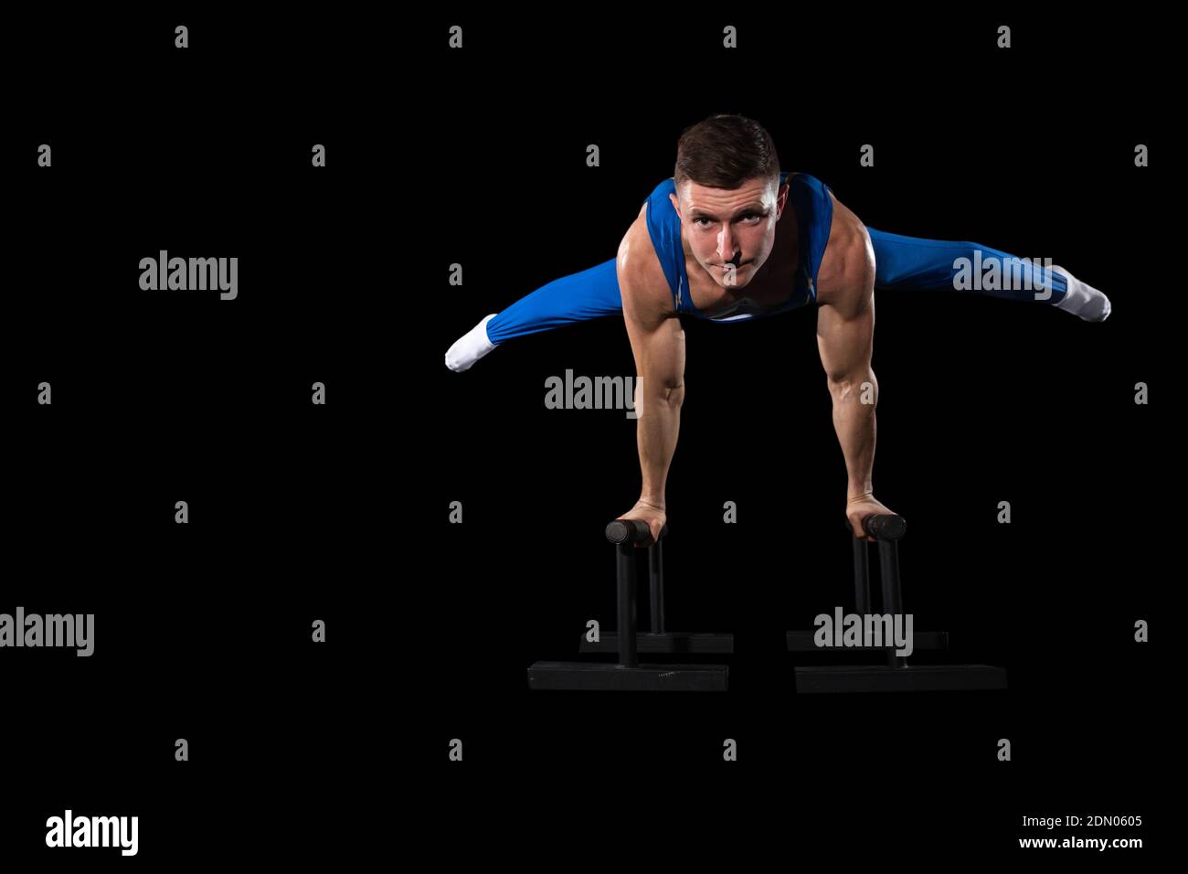 Energy. Muscular male gymnast training in gym, flexible and active ...