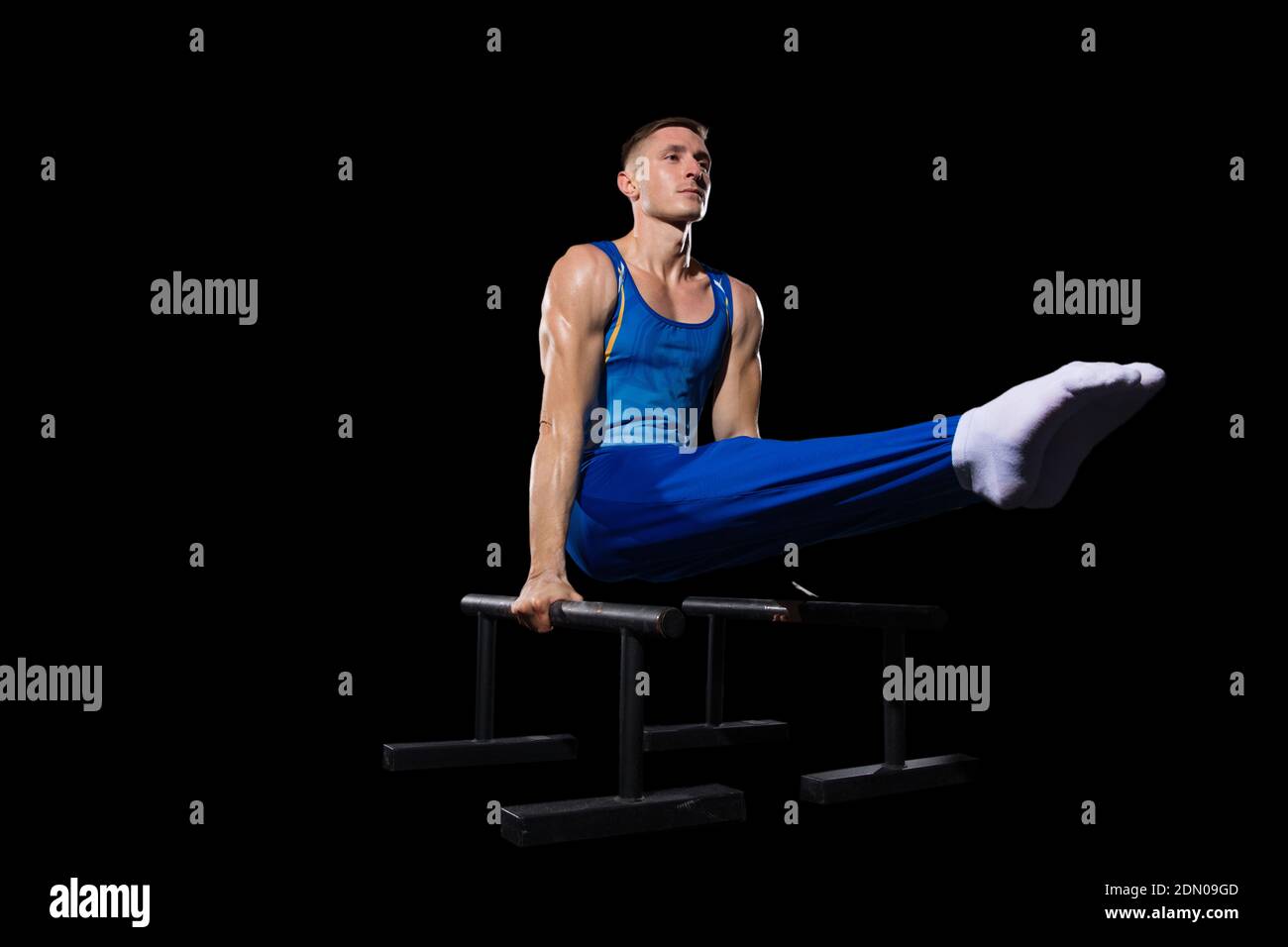 Experience. Muscular male gymnast training in gym, flexible and active ...