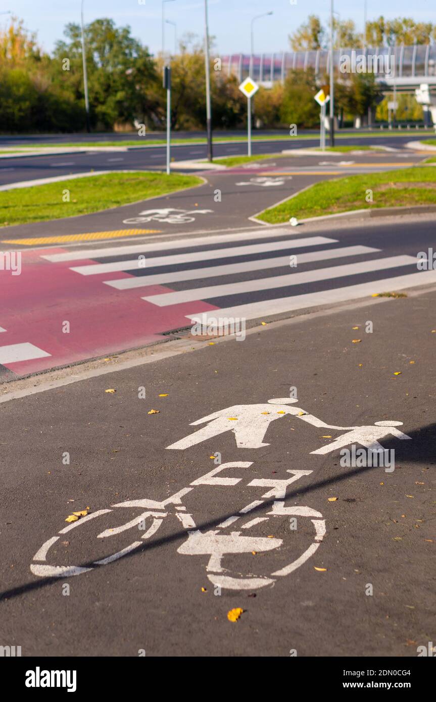 A vertical shot of pedestrian and bicycle signs on the asphalt street ...