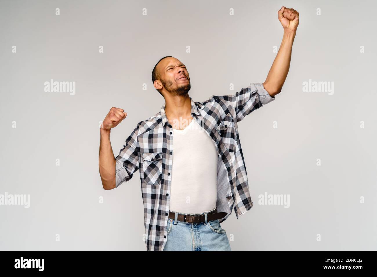 Young African-American man yes win gesturing over light grey background ...