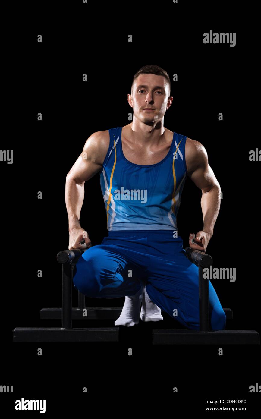 Professional. Muscular male gymnast training in gym, flexible and ...