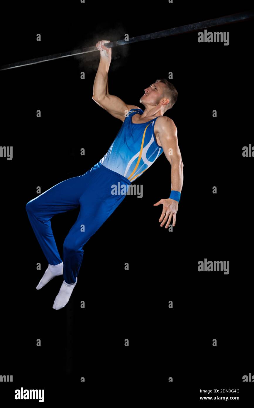 Flying. Muscular male gymnast training in gym, flexible and active ...