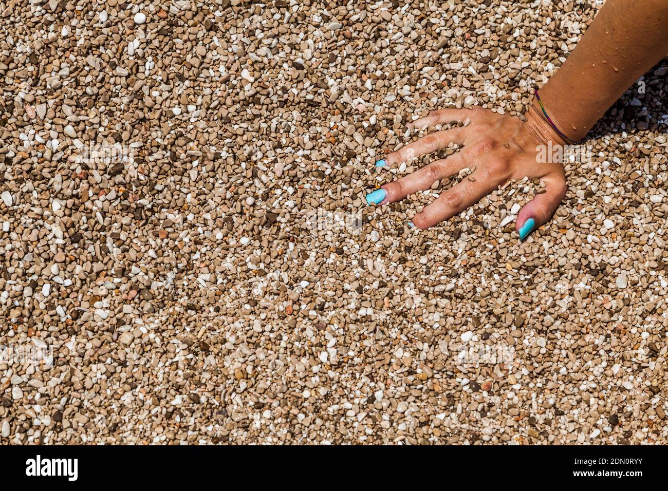 Female hand with cyan nails sinking in the sand at the sea Stock Photo ...