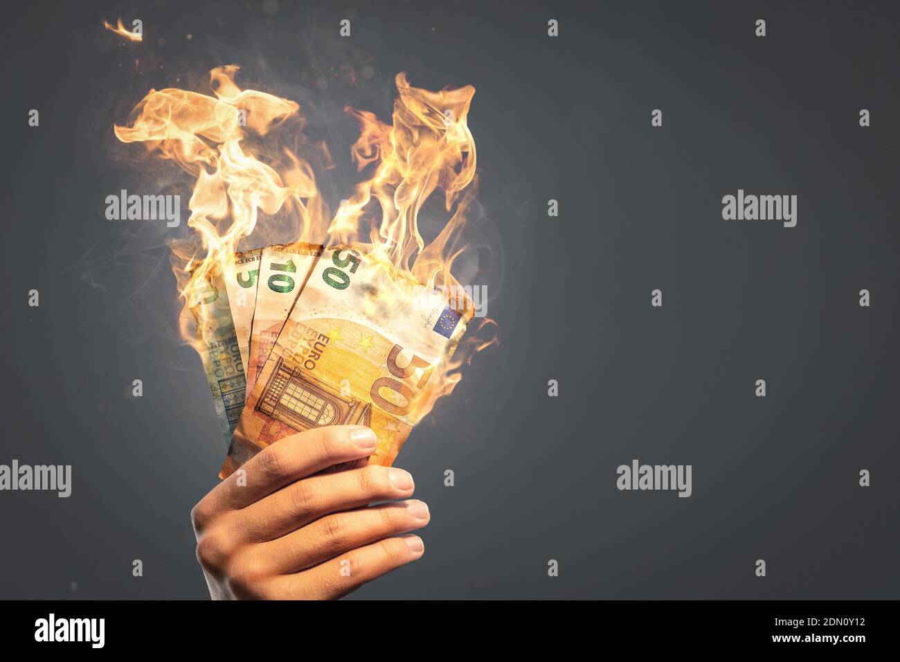 Burning Euro banknotes held by a hand Stock Photo - Alamy