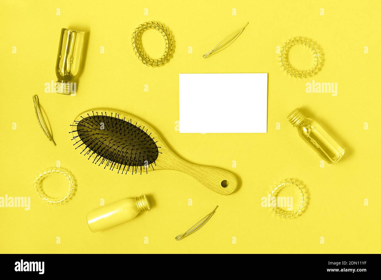 Flat lay of hair care products, styling items toned in trendy yellow ...