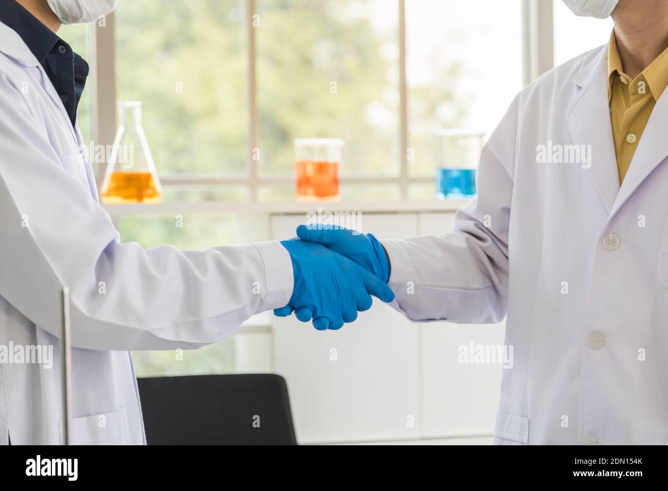 Scientists shaking hands in lab hi-res stock photography and images - Alamy