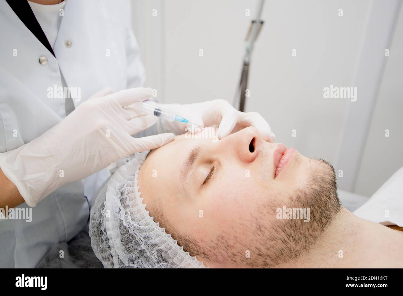 Cosmetologist's making injections to man's face to remove scars and ...