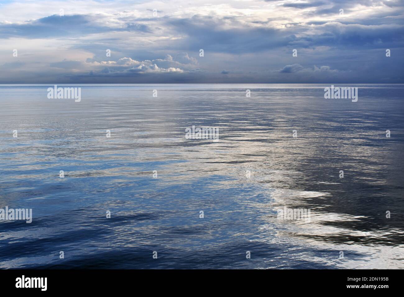 Flat sea in the evening with reflections Stock Photo - Alamy