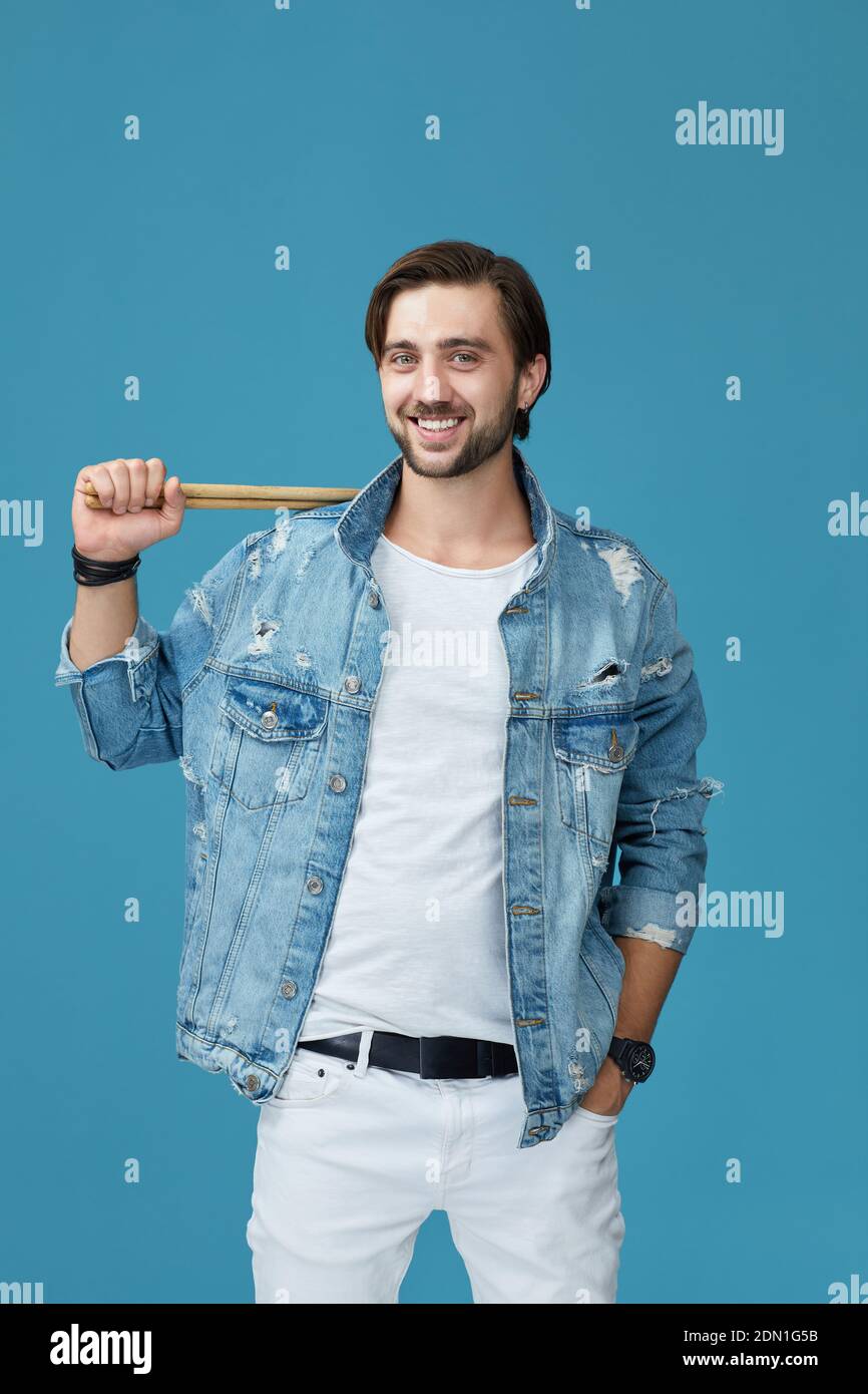 handsome smiling male drummer holding drummer sticks isolated on blue ...