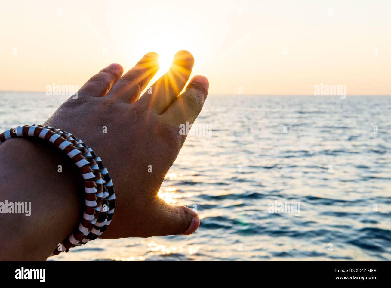 A man hand with the sun on the sunset sea. sunset picture on vacation ...