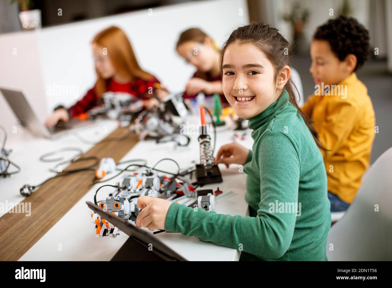 Group of happy kids programming electric toys and robots at robotics ...