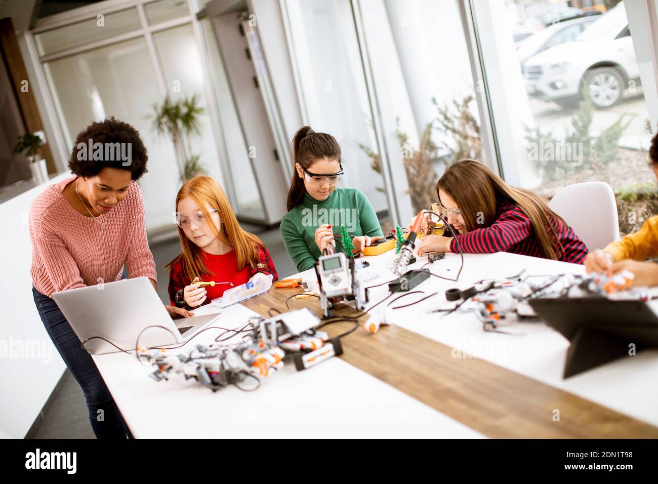 Group of happy kids with their African American female science teacher ...