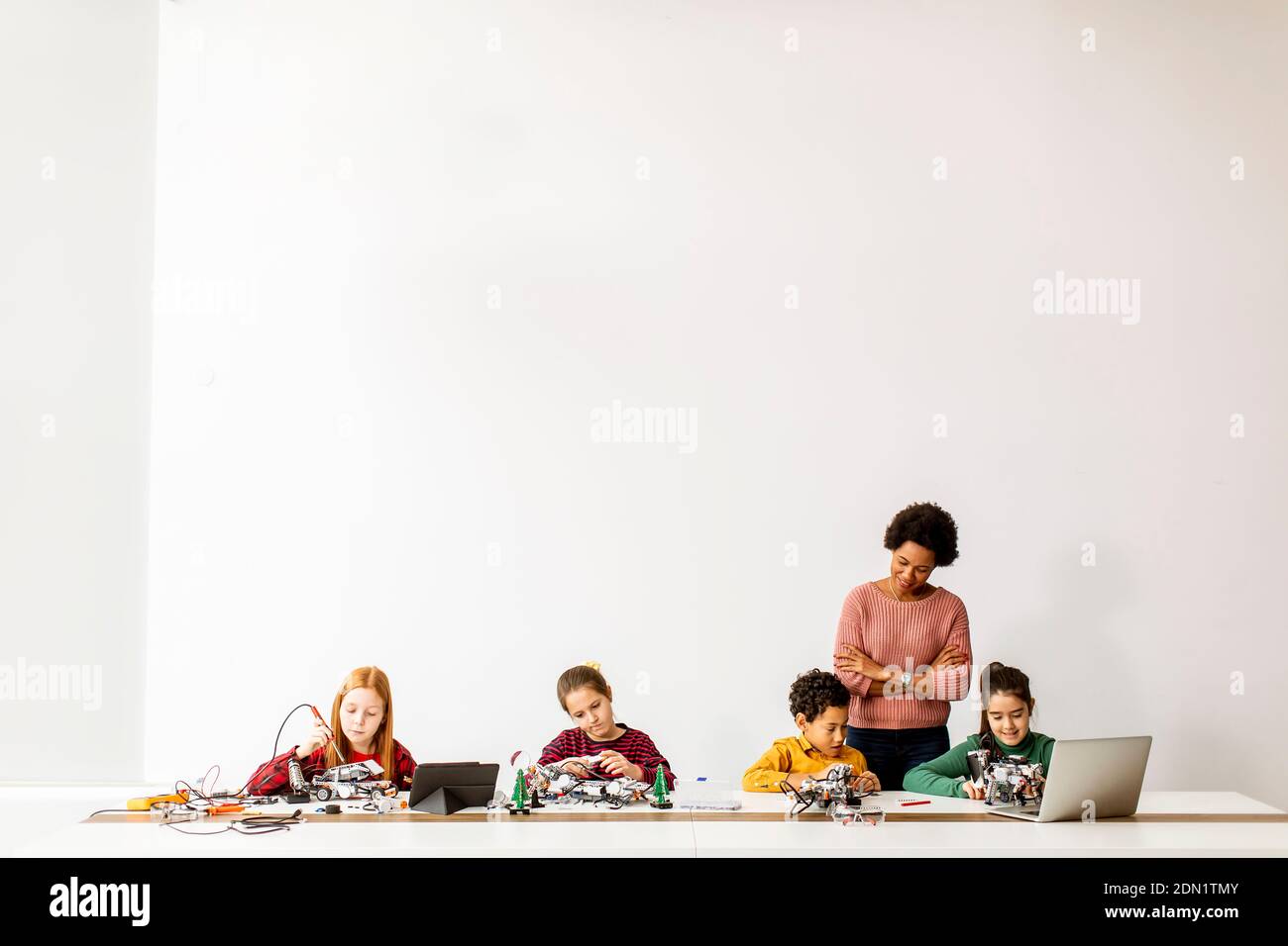 Group of happy kids with their African American female science teacher ...