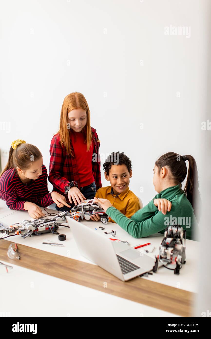 Group of happy kids programming electric toys and robots at robotics ...