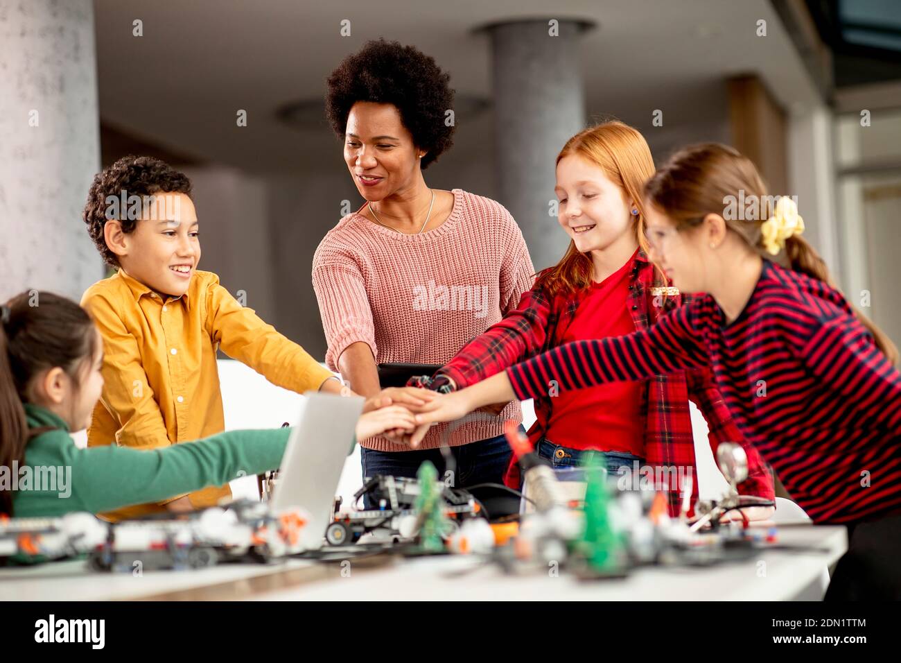 Group of happy kids with their African American female science teacher ...