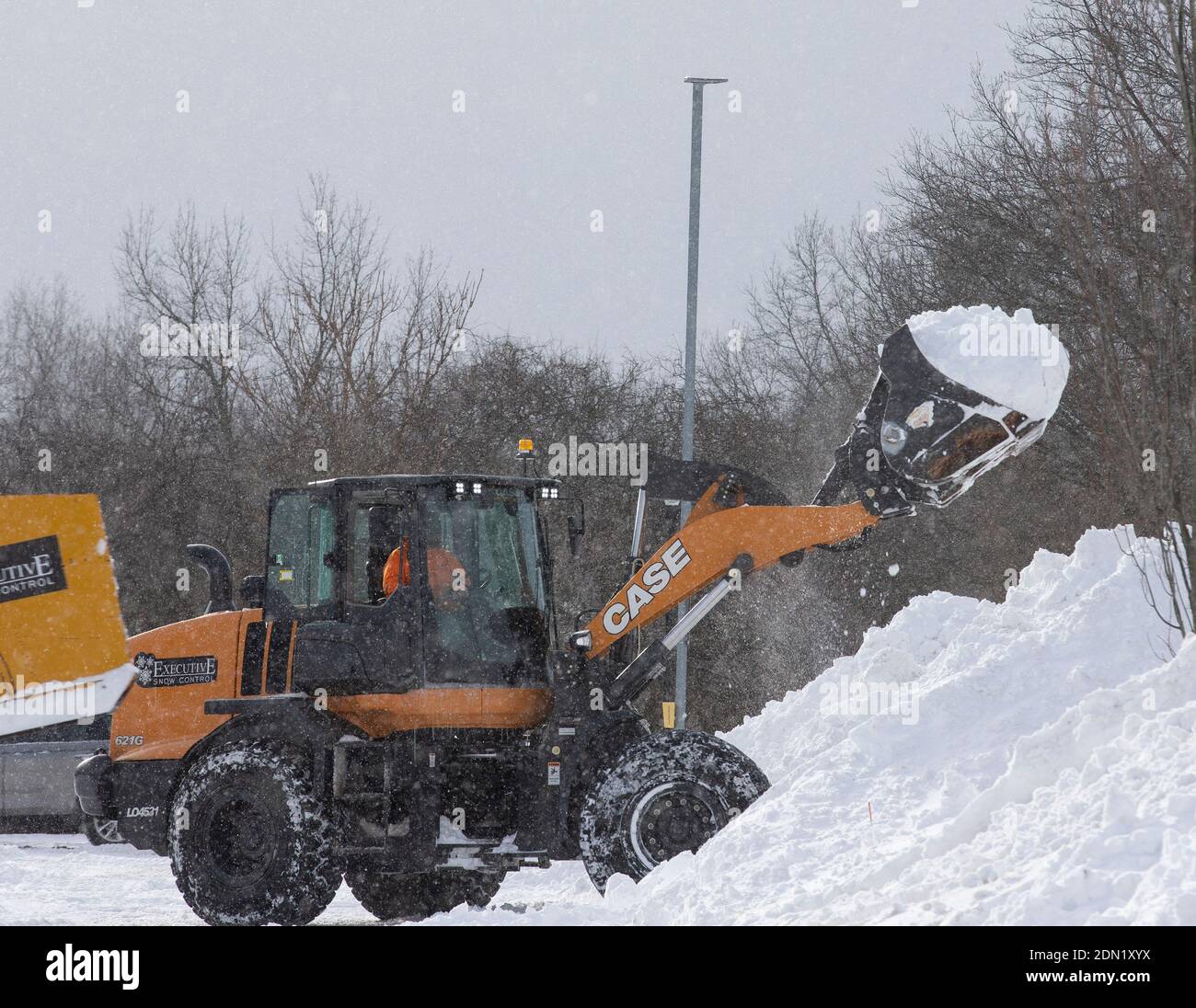 Snow plows removing show from a parking lot Stock Photo - Alamy