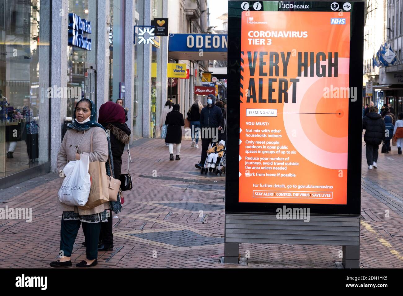 People pass a very high alert level warning sign while out and about ...