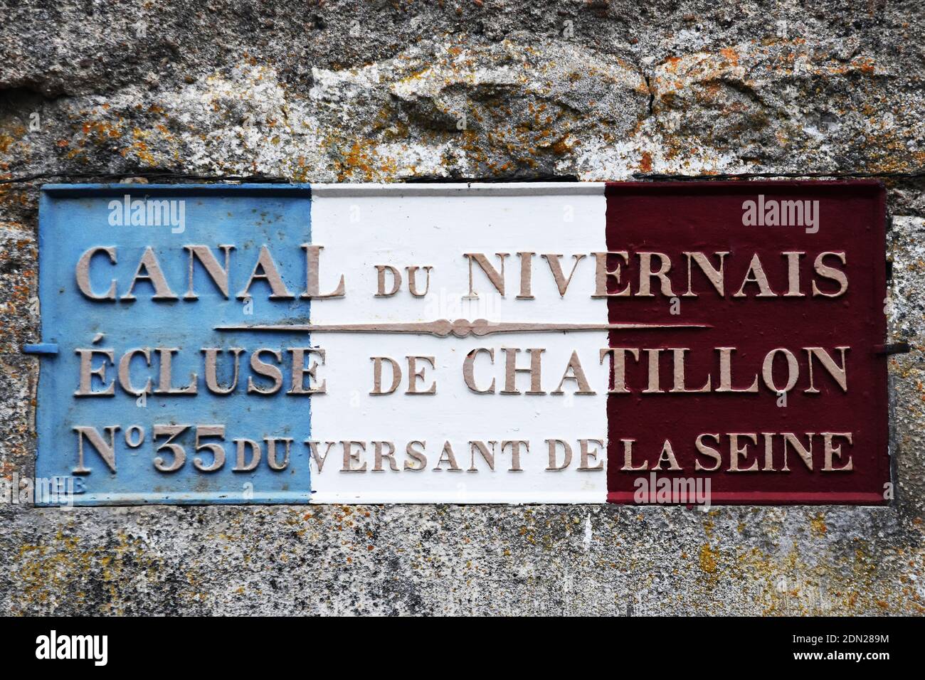French canal lock metal sign on a stone wall, painted with tricolor ...