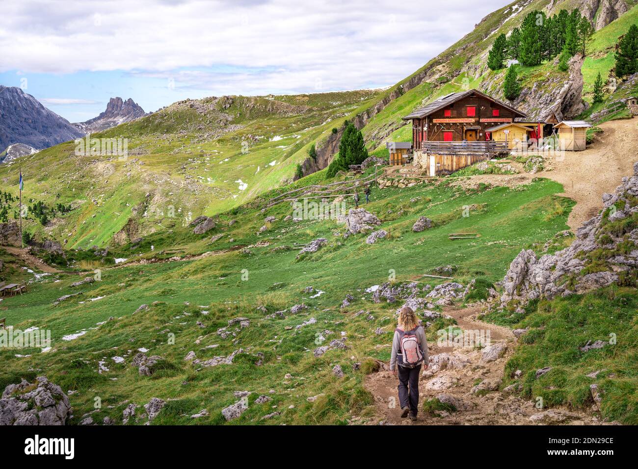 female hiker walking to wooden house in the austrian dolomites Stock ...