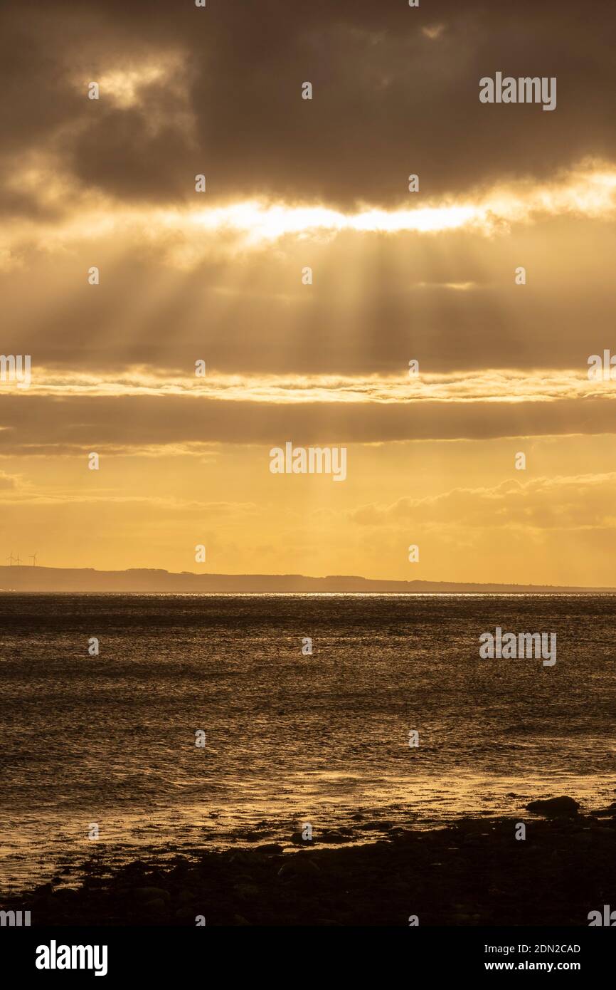 sun beams filtering through cloud by the sea Stock Photo - Alamy