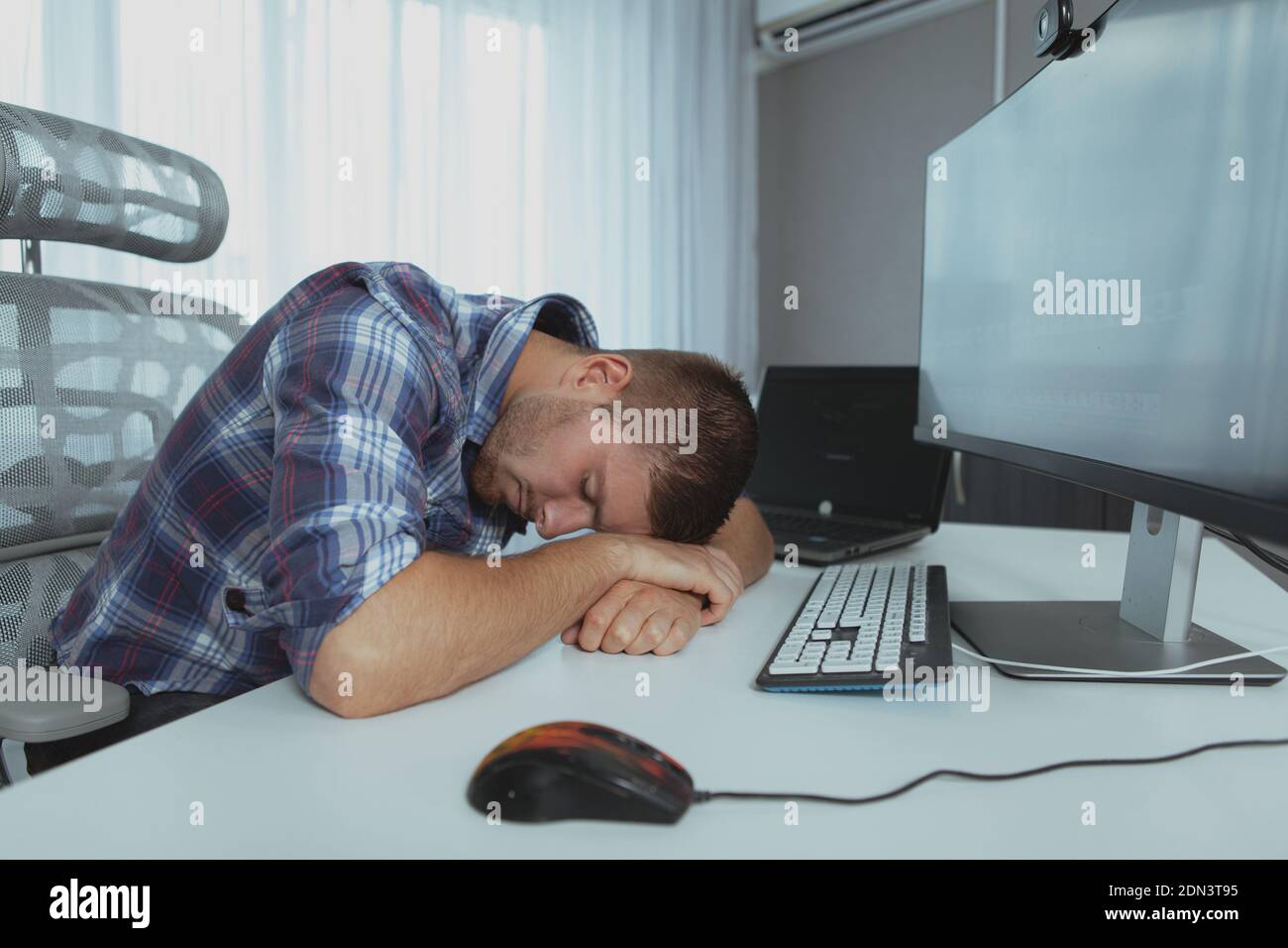 Handsome male freelancer sleeping on the desk in front of the computer ...