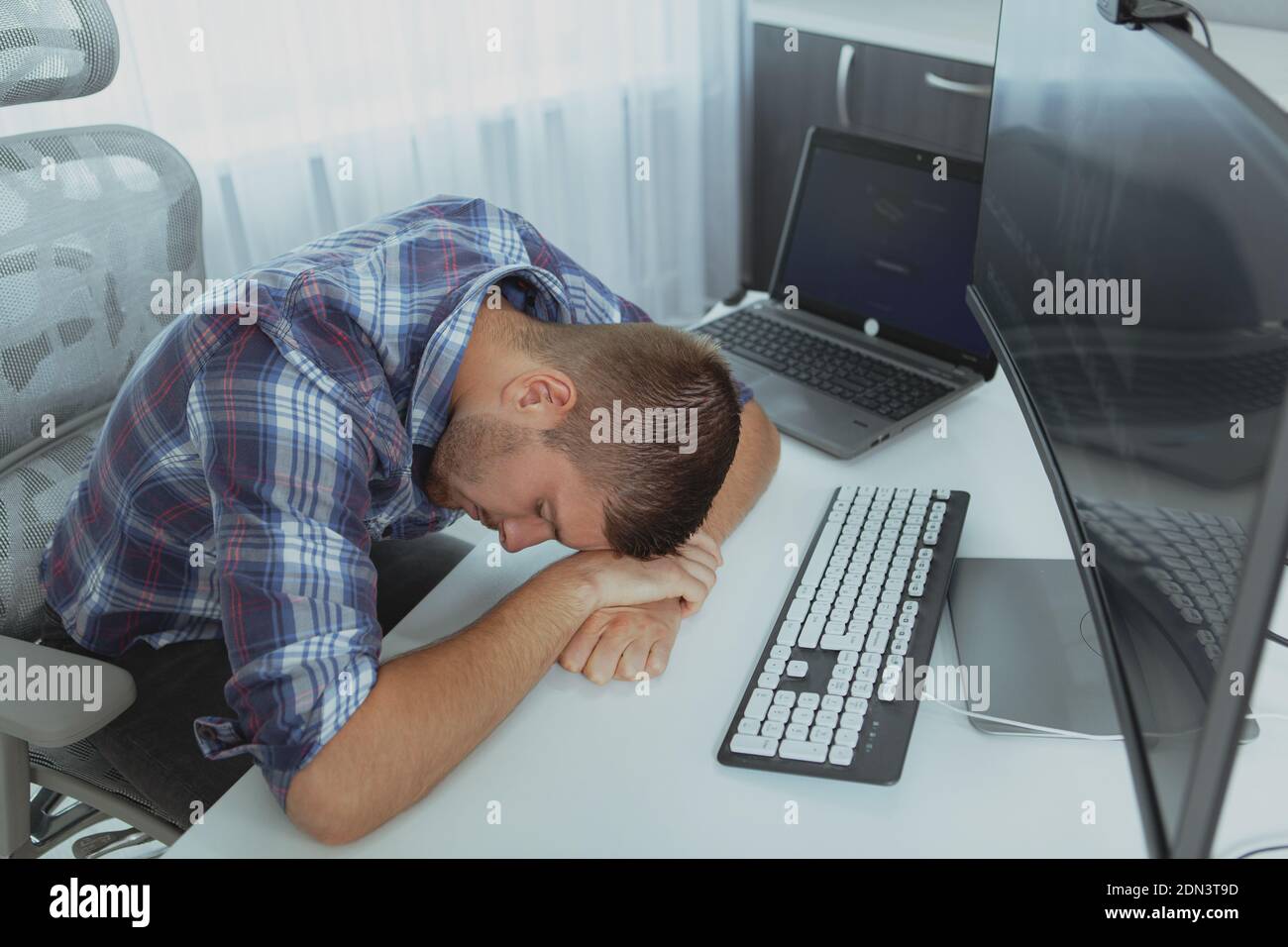 Top view shot of a program developer sleeping in front of his computers ...